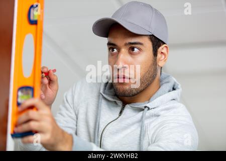 engineer checking wall with spirit level for level Stock Photo - Alamy