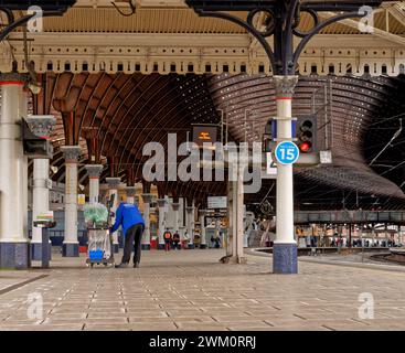 A railway station platform, lined by columns, curves, into a main concourse. A historic 19th ...
