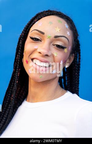 Image of young smiling woman with stickers on face writing in exercise ...