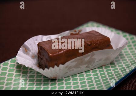 This image shows a piece of homemade chocolate fudge resting on a white ...