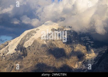 The Ortler Alps near Stelvo Pass at sunset in summer, clouds around the ...