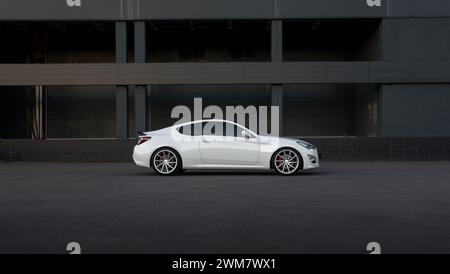 white Hyundai Genesis Coupe in the parking lot near the grey wall ...