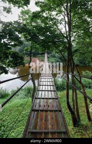 Hanging monkey bridge over the Minija river in Lithuania. Shot from a ...