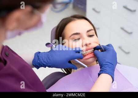 The dentist is checking the patient's mouth Stock Photo - Alamy