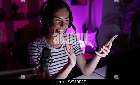 Young beautiful hispanic woman streamer playing video game using ...