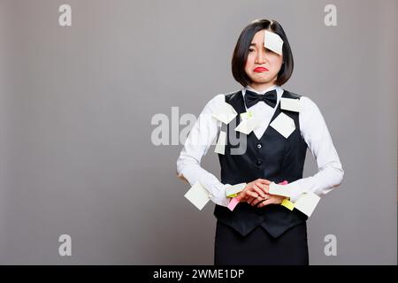 Stressed asian waitress overloaded with tasks sticky notes holding ...