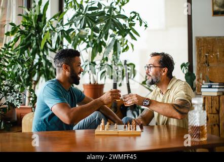 Best friends playing chess together, drinking whiskey and talking ...