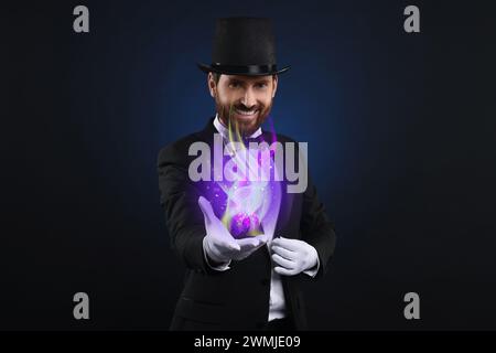 Magic and sorcery. Magician with fantastic light on dark background ...