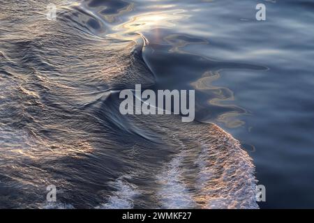Gentle blue waves, current on water's surface or wake from boat ...