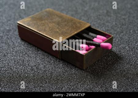 angle view copper matchbox with pink color match sticks at horizontal ...