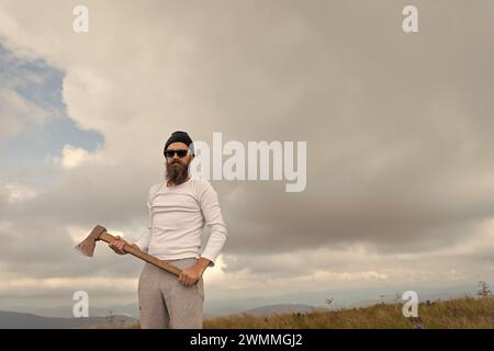 brutal bearded man lumberjack hold axe outdoor. bearded man lumberjack ...