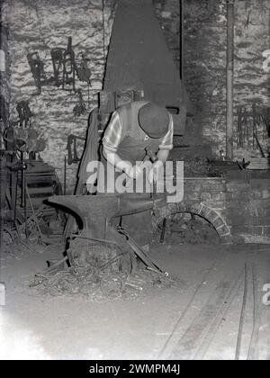 1970s, historical, a farrier working at a forge, England, UK. A ...