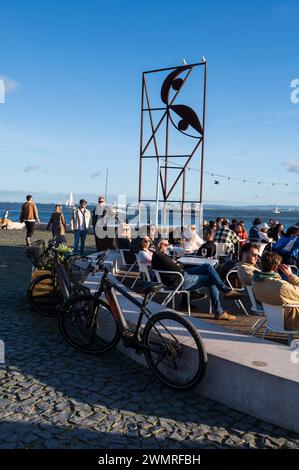 People enjoying the sunset on Ribeira das Naus, the riverfront ...