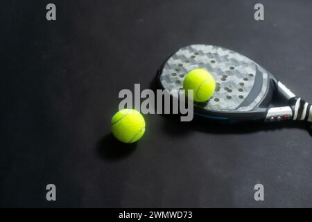 Detailed background of black and white padel racket and ball on black ...