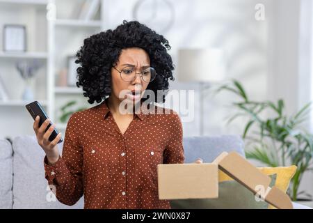 sad african american woman with parcel box at home Stock Photo - Alamy