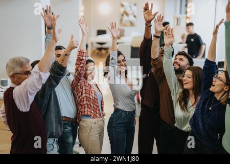 A vibrant office team celebrates with raised hands and beaming smiles ...
