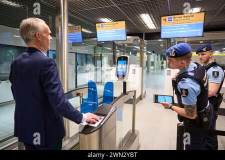 Passengers go through passport control booth at Chopin airport in ...