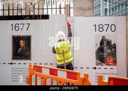 A contractor completes a protective hoarding that shows the face of ...