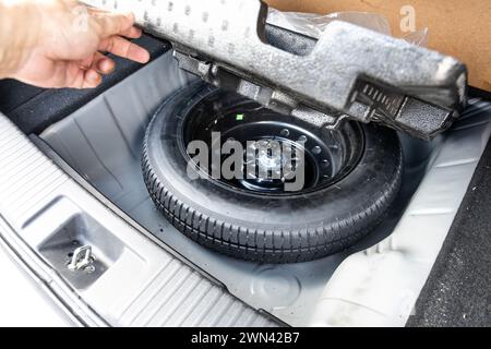 Temporary spare tire in the car boot for emergency use Stock Photo - Alamy