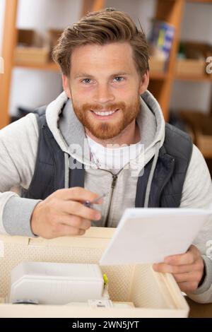 male worker doing stocktaking of product management on shelves in ...