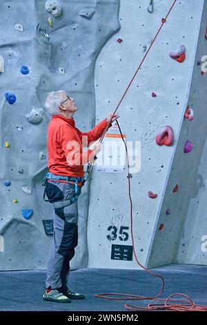Older climber belaying a partner as they climb Stock Photo - Alamy