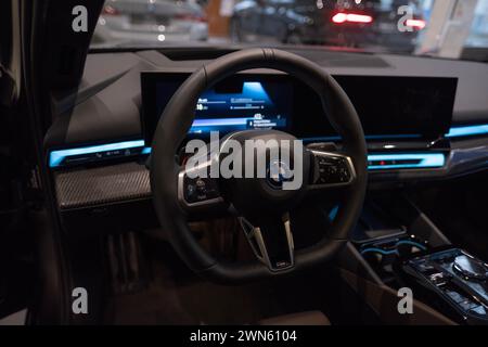 Interior, cockpit of BMW i5 eDrive40 car, digital panel, instruments on steering wheel, EV ...