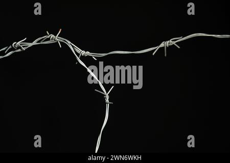 Shiny metal barbed wire on black background Stock Photo - Alamy
