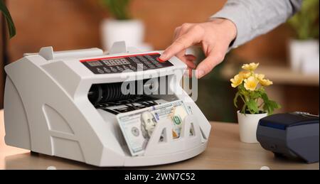 Male cashier using cash counting machine in flower shop Stock Photo - Alamy