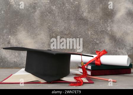 Mortar board with diploma and notebooks on beige background Stock Photo ...