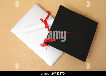 Mortar board with diploma and modern laptop on brown background Stock ...