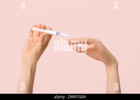 Female hands with cuticle oil pen, nail cutter and brush on white brick ...