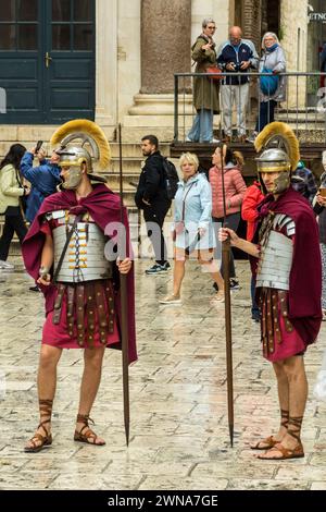 Actors in Roman soldiers' uniform posing with tourists for photographs ...