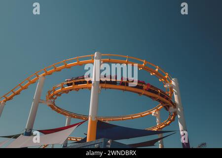 Moving roller coaster in an amusement park during the summer daytime ...