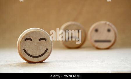 Wooden round with carved happy and angry faces, International Day of ...