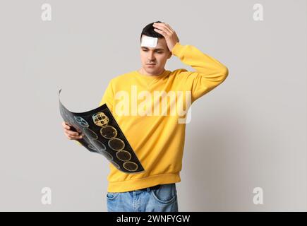 Young man with brain concussion and MRI scan on light background Stock ...