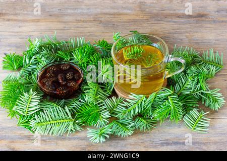 a drink made of pine needles in a cup with green fir needles on a ...