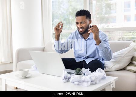 young attractive worried and stressed man at home calculating month tax ...