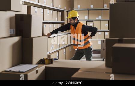 Tired warehouse worker having a bad back pain at work Stock Photo - Alamy