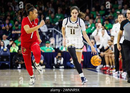 Louisville guard Sydney Taylor, center, chases the ball to keep it in ...