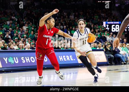Louisville guard Sydney Taylor, center, chases the ball to keep it in ...
