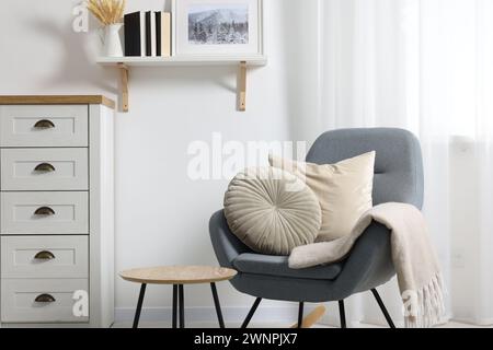 Soft pillows and blanket on rocking armchair indoors Stock Photo - Alamy