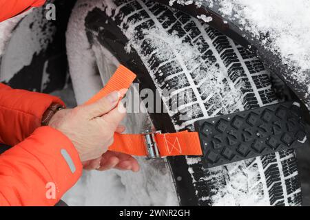 Japanese male attaching a temporary snow chain to a winter tyre Stock ...