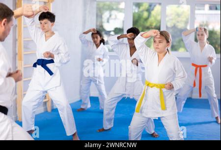 Girl with group of tweens performing kata routines during karate ...