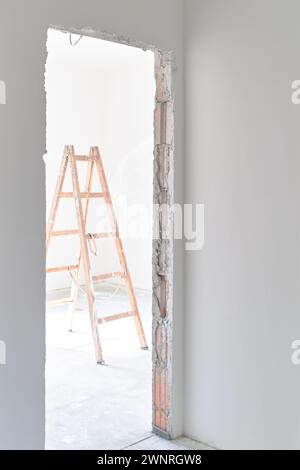 Ladder inside construction site doorway Stock Photo - Alamy