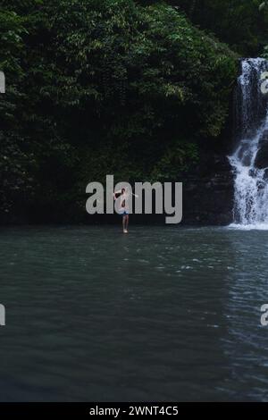 Man jumps from a cliff into the Alin-Alin waterfall. Bali Stock Photo ...