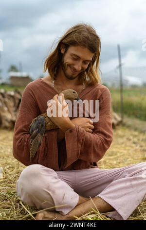 Smiling long-haired man holds duck in his hands Stock Photo - Alamy