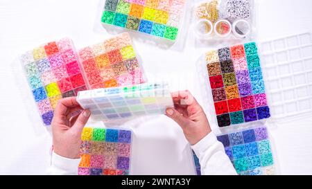 Woman's Hands Amidst a Rainbow Array of Beads for Jewelry Crafting ...
