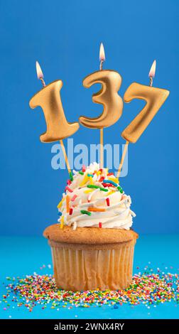 Candle number 137 - Cupcake birthday in blue background Stock Photo - Alamy
