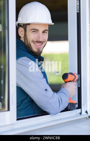 man is drilling a window frame Stock Photo - Alamy