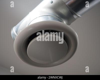 Extractor hood in a public toilet. Round metal pipe with gray air ...